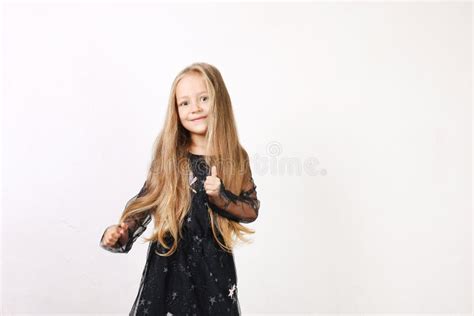 Liten Blond Flicka Med Långt Guld Hår Som Bär Den Svarta Klänningen