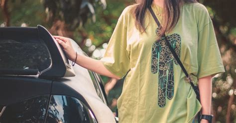 10대 거리 패션 검은 차 곁눈질 공원 나무 녹색 녹색 티셔츠 도시 도시의 라이프스타일 머리카락을 풀어헤치다 멀리 보아라 모델 모자 밝은 날