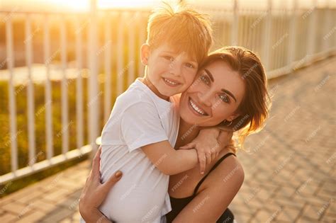 Alegre Madre E Hijo Abrazándose En El Puente Foto Premium