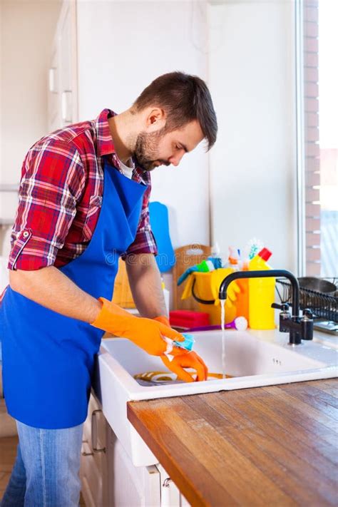 Luomo Fa La Pulizia Della Cucina Il Giovane Lava I Piatti Cle Immagine