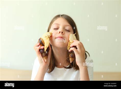A Young Girl In Her Backyard Holding A Snail In Her Hand She Has A Curious And Fascinated