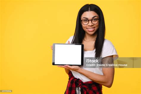 웃고있는 젊은 아프리카 소녀 여자 여학생 매니저 들고 디지털 태블릿을 사용하여 노란색 배경 복사 공간에 격리 된 빈 화면 모형을 보여줍니다 기술 개념 20 24세에 대한