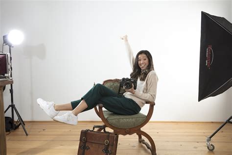 흰색 긴팔 셔츠와 파란색 데님 청바지를 입은 여자가 갈색 나무 의자에 앉아 있습니다 사진 Unsplash의 무료 사람 이미지