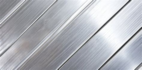 A Metallic Surface Featuring Diagonal Lines That Create A Dynamic Light Reflection Stock Image