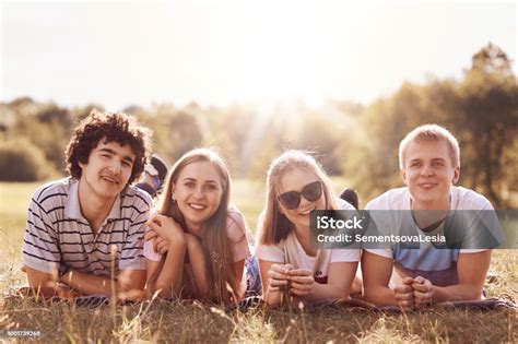 웃는 친구 들이 행복 한 식 지상에 격자 무늬에 기 뻐 화창한 날 카메라 자유 시간을 함께 보내고 십 대 Groupmates 시작 여름 휴일 축 하 소풍 남자에 대한 스톡