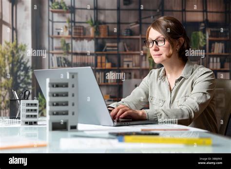 Female Architect Designer Works On A Project Laptop And Blueprints On Table Architect Designer