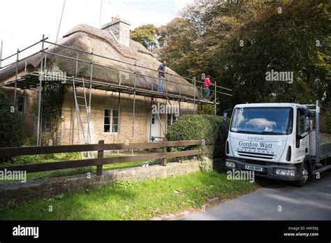Scaffold Workers Erecting Scaffold On Thatched Cottage Stock Photo Alamy