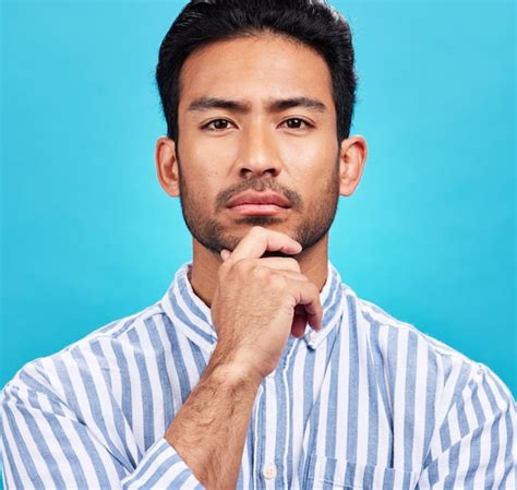 Premium Photo Portrait Of Man On Blue Background Thinking And Serious Expression And Hand On