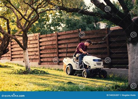 Man Using Lawn Tractor For Mowing Grass Landscaping Works With