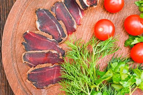 close up of assorted sliced dry cured meat on the wooden plate