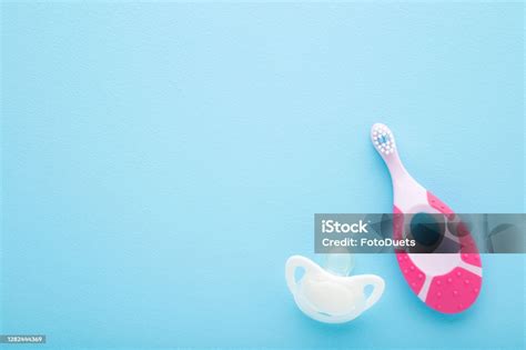 밝은 파란색 테이블 배경에 흰색 Soother 및 분홍색 아기 칫솔 파스텔 색상 아기 치아 위생 근접 촬영 텍스트의 빈