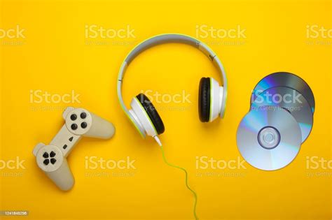 게임 패드와 스테레오 헤드폰 노란색 배경에 Cd 디스크 게임 레저 및 엔터테인먼트 개념 맨 위 보기입니다 0명에 대한 스톡 사진