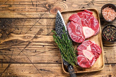 생 송아지 크로스 컷 생크 고기 Osso Buco 요리 이탈리아 Ossobuco 나무 배경 맨 위 보기입니다 복사 공간 검은색에