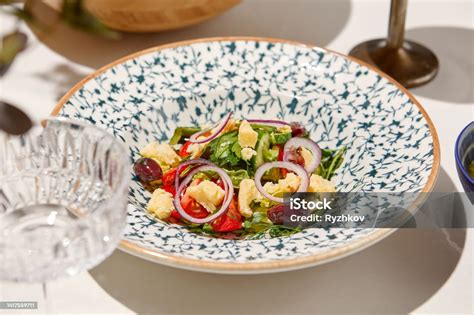 전통적인 이탈리아 음식 토마토 양파 반지 및 크루톤이있는 판자넬라 샐러드 여름 메뉴의 흰색 테이블에 판자넬라 샐러드 화창한 날에