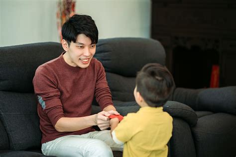 아시아 중국어 미소 젊은 남자 주는 빨간 봉투 에 소년 에 생활 관 에 중국 설 날 중국 민족에 대한 스톡 사진 및 기타 이미지
