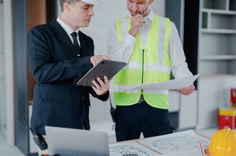 Multi Ethnic Engineer Brainstorming And Measuring For Cost Estimating