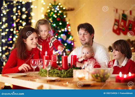 Familie Met Kinderen Die Kerstdiner Hebben In De Boom Stock Foto