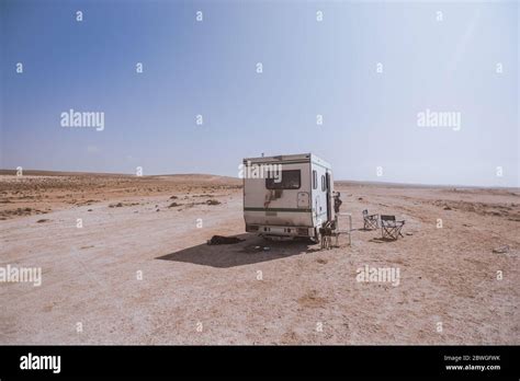 Old Rusty Camper Van In The Sandy Desert Field Camping Site In The