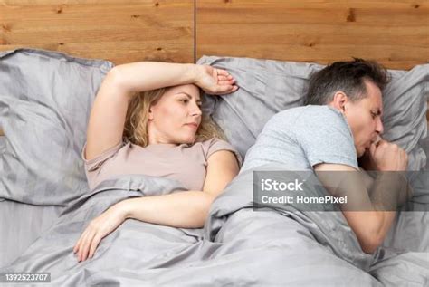 침대에서 두 명 한 여자가 꿈에서 엄지 손가락을 빨아 먹는 그녀에게서 돌아 선 잠자는 남자를 바라 봅니다 관계 개념 40 49