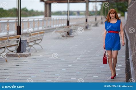 Красивая женщина в голубом платье и красных ботинках Стоковое Фото