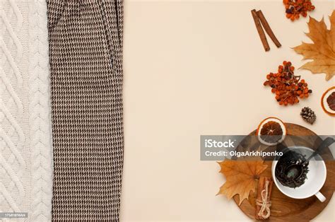 플랫 레이 가을 구성 찻잎 나무 접시 니트 패션 스웨터 또는 격자 무늬 패턴의 바지 노란색 단풍 잎 계피 베이지 색 배경에