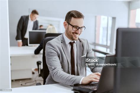 웃는 백인 사업가 양복과 안경 그의 직장에 앉아서 컴퓨터를 사용 하 여 키보드에 손 미소에 대한 스톡 사진 및 기타 이미지