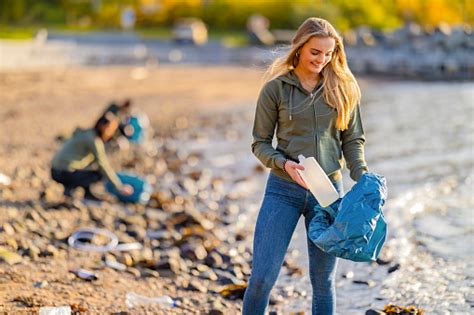 해변에서 병과 쓰레기 봉투를 들고 미소 짓는 젊은 여성 자원 봉사자 가방에 대한 스톡 사진 및 기타 이미지 가방 개선 공동체 Istock