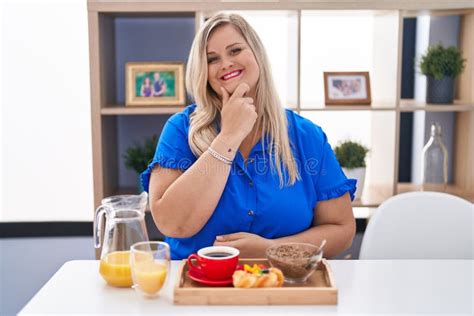 Caucasian Plus Size Woman Eating Breakfast At Home Looking Confident At