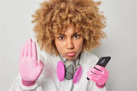 Premium Photo Serious Female Scientist Keeps Palm Raised Wears Hazmat