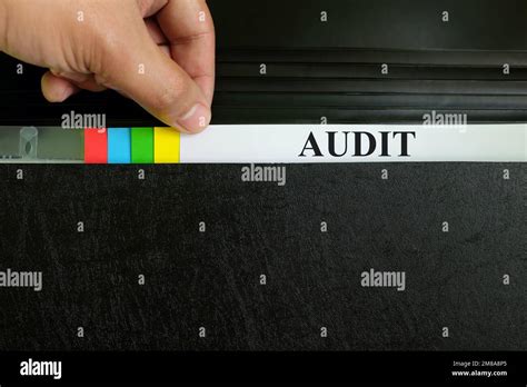 Hand Picking Audit Report File Record In Black Binder Folder Auditing