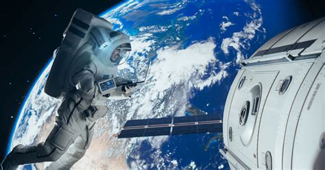 무중력 상태에서 우주를 떠다니는 젊은 우주 비행사 궤도를 도는 우주선 외부의 열린 공간에서 랩톱 컴퓨터를 사용하는 우주인 위성 유지 보수 작업을 위한 사용 설명서 검색