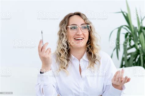 금발과 곱슬 머리를 가진 행복한 젊은 여성의 비즈니스 초상화 미니멀 한 사무실의 배경에 대해 화상 통화 25 29세에 대한 스톡 사진 및 기타 이미지 Istock