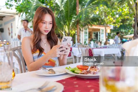 Z세대 아시아 여성이 해변가 레스토랑에서 태국 해산물 요리를 맛보기 전 순간을 포착합니다 레스토랑에 대한 스톡 사진 및 기타