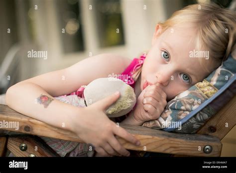 Girl Lying In A Chair Sucer Son Pouce Photo Stock Alamy