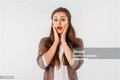 젊은 겁에 질린 여자의 초상화 놀란 겁에 질린 여성은 입에 손을 대고 대학에서 퇴학당하는 것에 충격을 받고 카메라를 보고 흰색