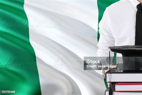 성공적인 나이지리아 학생 교육 개념입니다 나이지리아 국기 배경 위에 책과 졸업 모자를 들고 나이지리아 국기에 대한 스톡 사진 및 기타 이미지 Istock