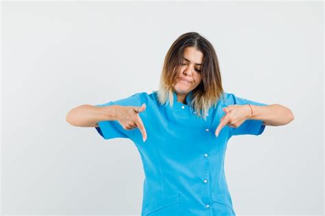 Dottoressa Che Punta Le Dita Verso Il Basso In Uniforme Blu E Sembra Concentrata Foto Gratis