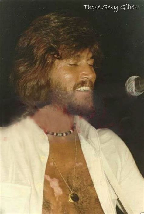 A Man With No Shirt On Singing Into A Microphone