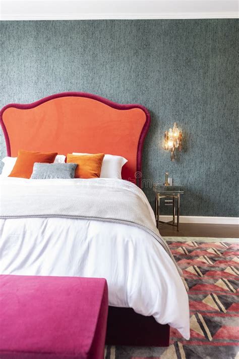 Modern Luxurious Red Tone Bed With Crystal Wall Lamp In Interior Stock