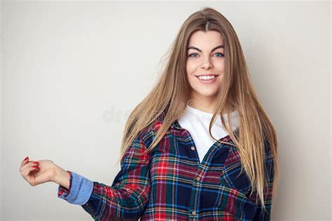 Happy Young Woman In Plaid Shirt Posing Against Wall Stock Image