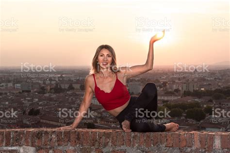 따뜻한 배경을 가진 아름다운 도시 위치에서 일몰이나 일출에서 태양을 들고 요가 위치에있는 충실한 여성의 뒷빛의 전면 보기 50 54세에 대한 스톡 사진 및 기타 이미지