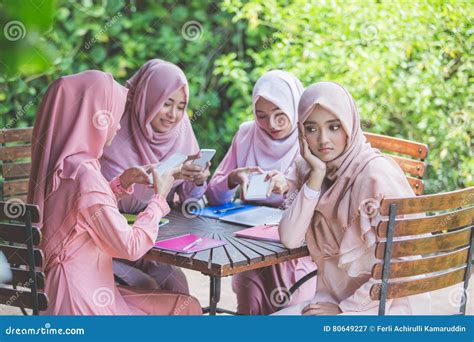 Young Girl Using Their Own Smartphone And Ignoring Her Friend Stock