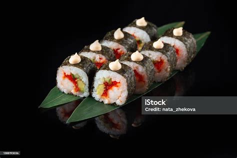전통적인 맛있는 신선한 스시 롤은 반사와 검은 배경에 설정 쌀 노리 크림 치즈 토비코 캐비어 아보카도와 함께 스시 롤 초밥 메뉴