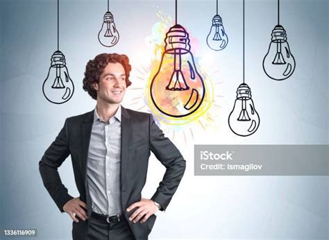 허리에 손을 가진 자신감 히스패닉 잘 생긴 사업가는 노란색 화려한 비즈니스 아이디어 전구 스케치와 밝은 파란색 벽 근처 를 숙고하고있다 창의성과 브레인스토밍의 개념 개념에