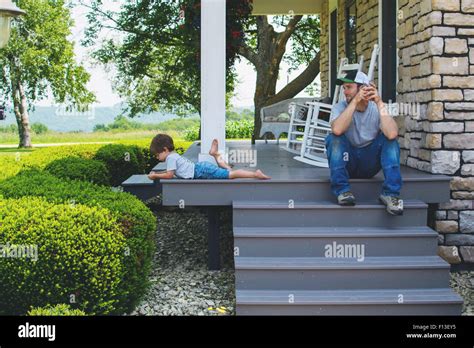 Mann Sitzt Auf Der Veranda Schritte Sohn Betrachten Stockfotografie Alamy