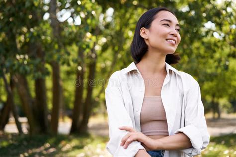 Image Of Korean Girl Walking In Park Smiling While Having A Mindful