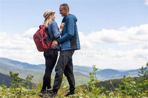 Rear View Of Hiking Couple With Backpack Standing Together On Hill Top