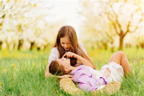 Deux Filles Soeurs S Amusent Et Se C Linent Dans Le Jardin Avec Des Arbres Fleurs Image Stock