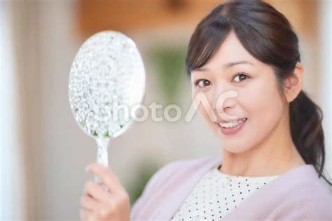 手鏡を持ってカメラ目線の女性 No 26998677｜写真素材なら「写真ac」無料（フリー）ダウンロードok