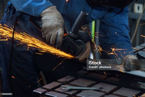 금속 연삭 마스터가 있는 금속 세공 작업장에서 그라인더가 공장에서 스파크를 일으킵니다 그라인더 산업 장비에 대한 스톡 사진 및